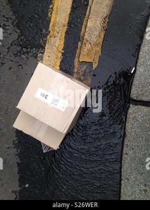 Litter in a puddle on city street in England. UK Stock Photo - Alamy