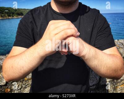 A man cracking his knuckles together Stock Photo - Alamy