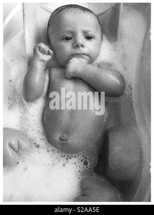 First bath of newborn baby boy, the mom washes the baby with natural ...