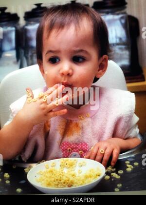 A baby eating messily in a high chair Stock Photo - Alamy
