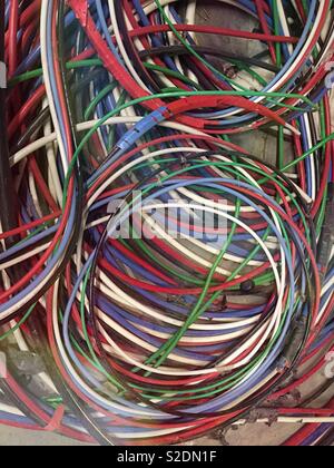 Electrical cable pile. tangled mess of electrical wires bulge out from ...
