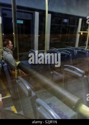 Inside an empty bus at night, showing some window reflections as well ...