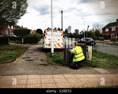Openreach engineer working on pavement sited telephone junction box ...