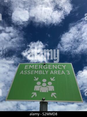 Emergency assembly area sign against blue sky Stock Photo - Alamy