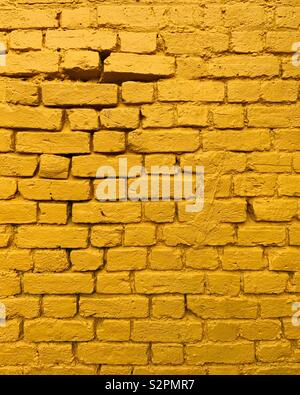 A texture of mustard yellow brick wall, showing the vertical ...
