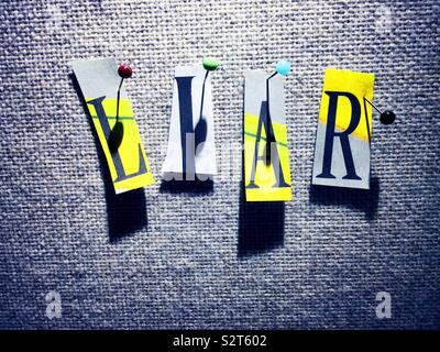 The word Liar on a bulletin board using cut-out paper letters in the ...