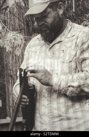 Man loading bullets into gun, close-up of hands Stock Photo - Alamy
