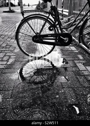 A bicycle wheel in a rain puddle Stock Photo - Alamy
