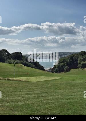 Golf course putting green and cliffs by the pacific ocean bay. Half ...