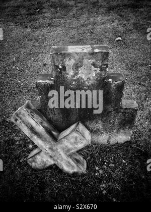 Fallen cross in graveyard uk Stock Photo - Alamy