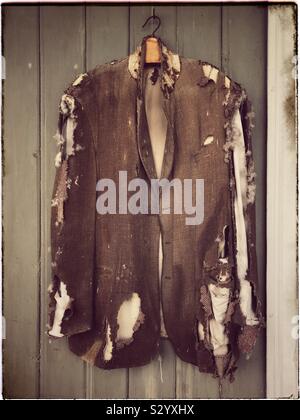 An old jacket disintegrating on its clothes hanger as it has been left ...