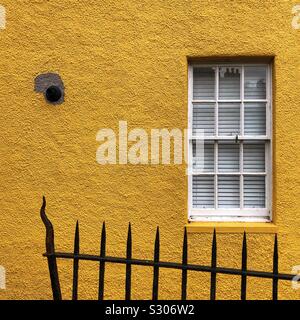 Railings against yellow roughcast wall with boiler vent Stock Photo - Alamy