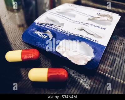 close up of a blister pack containing red and white capsules of a ...