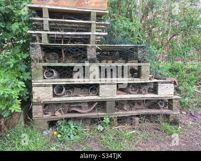 A bug hotel for insects made from old wooden pallets in a wild corner ...