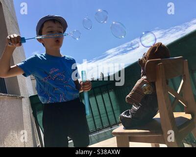 Teddy bear blowing soap bubbles above a toy shop in Haga, the historic ...