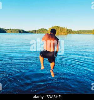 Man jumping in lake Stock Photo - Alamy