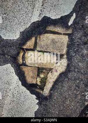 Damage pavement surface can see under cobblestone street in Spain Stock ...