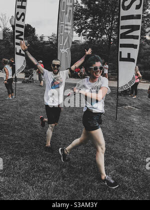 Happy girl reaching finish line and winning race competition in park ...