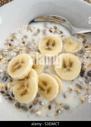 Bowl with slices banana and muesli on wood table. Healthy eating ...