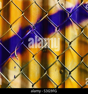 Chain link fence in front of asphalt roadd with white road markings ...