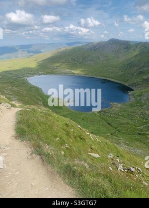 View of Helvellyn from Red Tarn on a sunny day with the mountain ...