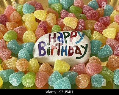 Happy Birthday text carved and colored on a stone with mountains ...