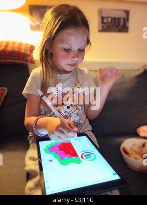 Little girl is using Apple iPad to draw and entertain herself at home ...