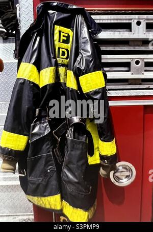 Firefighter, uniform and clothing hanging on wall rack at station for ...