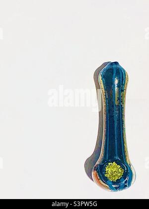 Medicinal marijuana against a white background. Black grinder open with ...