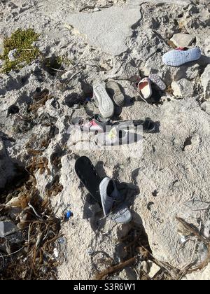 Shoes and trainers washed up on beach in a line Stock Photo - Alamy