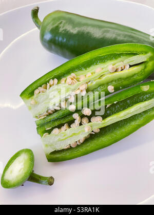 Close-up of sliced green jalapeno peppers in white rectangular dish ...