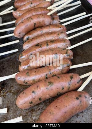 hand of the cook while cooking with bbq sausages and cooked pork ribs ...