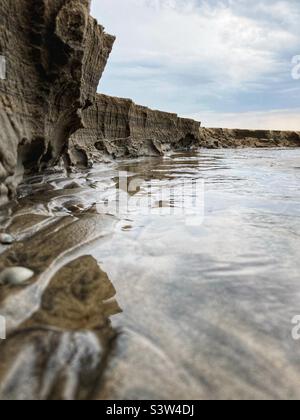Close up of the Scarp of a Small River crossing a Beach and flowing ...