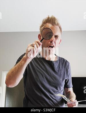 man looking at ring through magnifying glass Stock Photo - Alamy