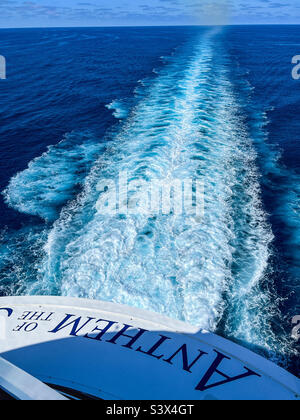 Cruise ship wake stretching from the stern to the blue sky horizon ...