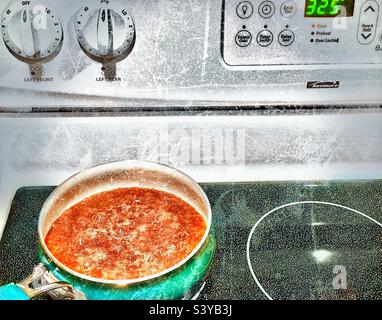 Delicious simmering brown gravy on a stovetop on Thanksgiving day in a ...