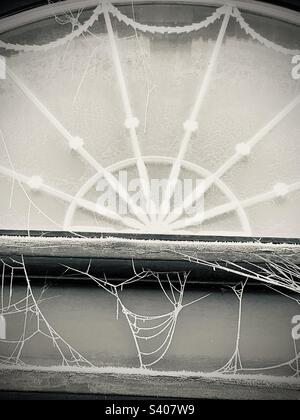 An arched window with frozen cobwebs hanging from it. Black & white ...