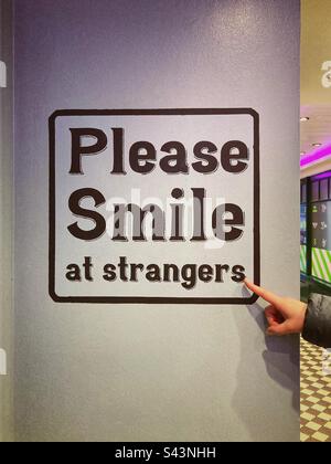 Please smile at strangers sign Stock Photo - Alamy