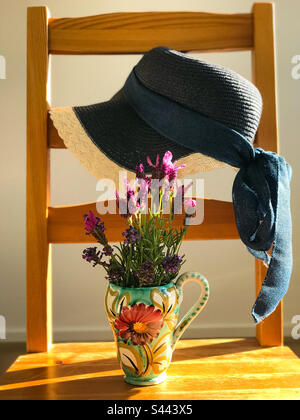 Close-up of a hat on lavender flowers on a sunset background. Love in ...