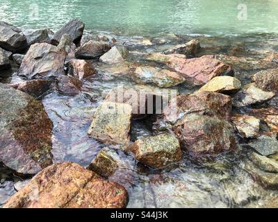 Rocks at the beach colorful half submerged in the tide Stock Photo - Alamy