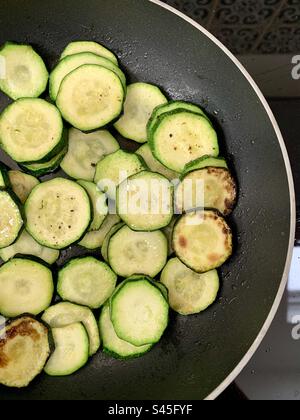 Frying zucchini fried courgettes vegetables and chopped rosemary herbs ...