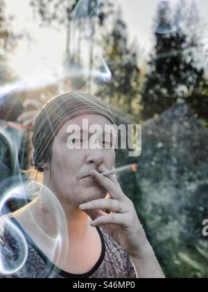Woman smoking a big joint at sunset Stock Photo - Alamy
