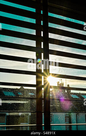 Sun shining through window blinds. The bright sun breaks through the ...
