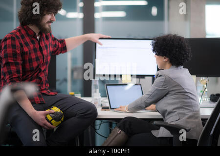 young software developers couple using laptop and desktop computer ...