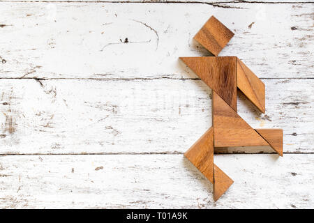 Tangram puzzle in happy running man shape on old white wood background ...