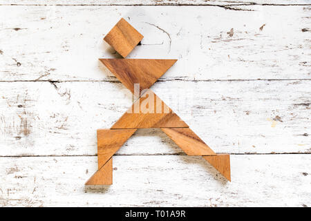 Tangram puzzle in happy running man shape on old white wood background ...