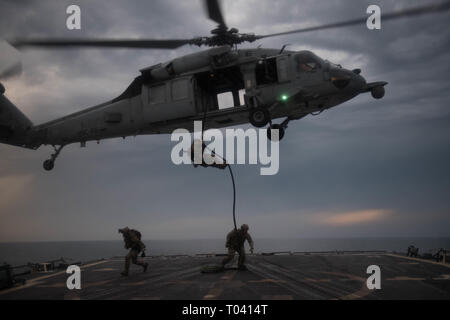 Three members of a U.S. Navy sea-air-land (SEAL) team ride in a ...