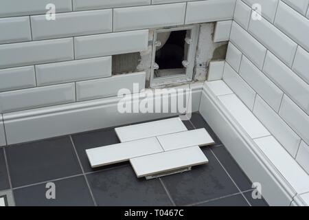 Open hidden revision sanitary hatch on the wall of tile under the ...