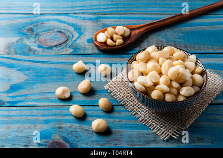 Macadamia inside ceramic pot on blue pine wood Stock Photo - Alamy