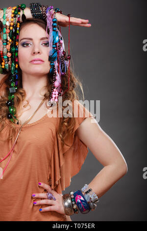 Pretty young woman wearing bracelets and rings holding many plentiful ...